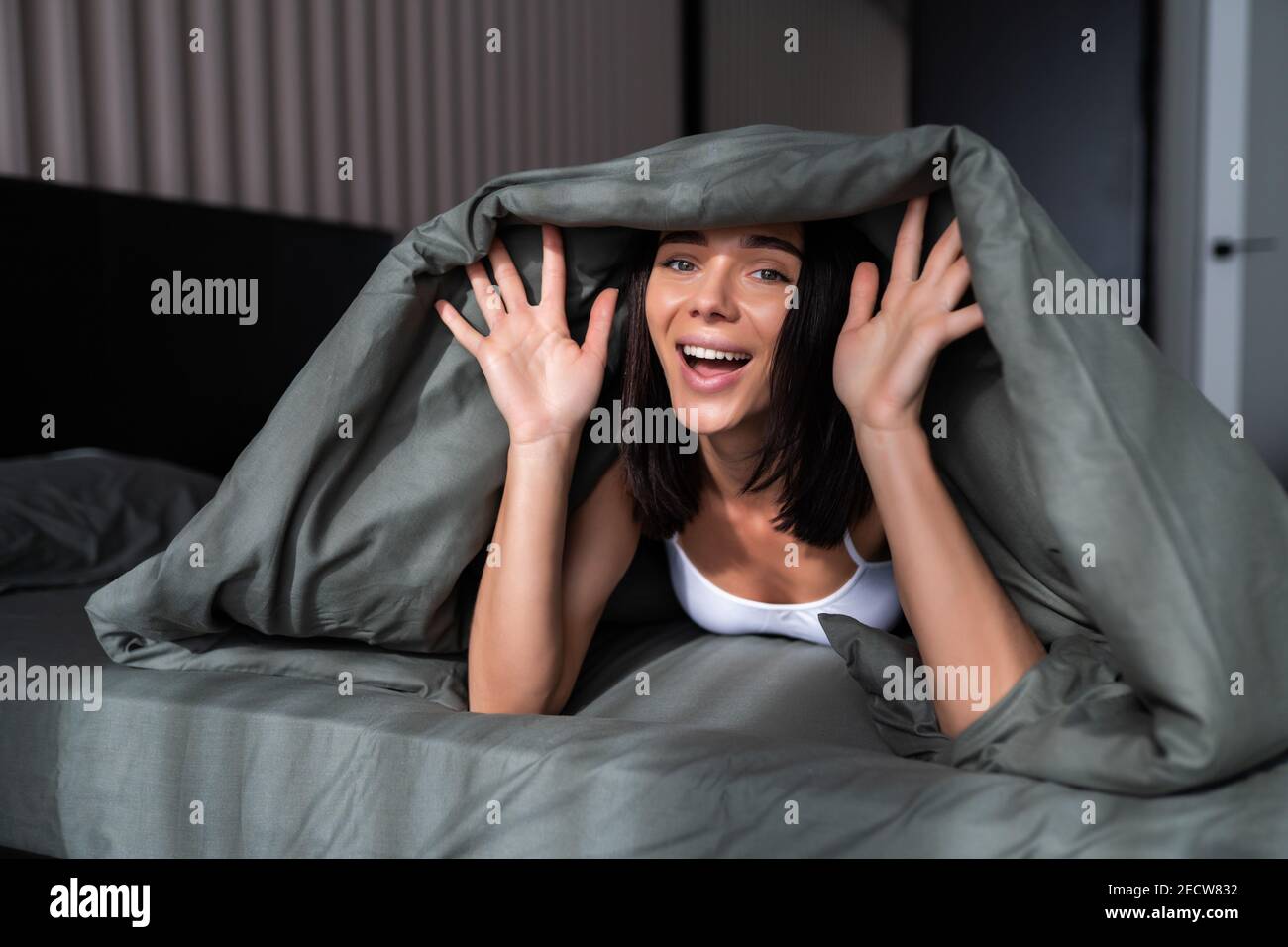 Beautiful woman in bed under the sheets Stock Photo - Alamy