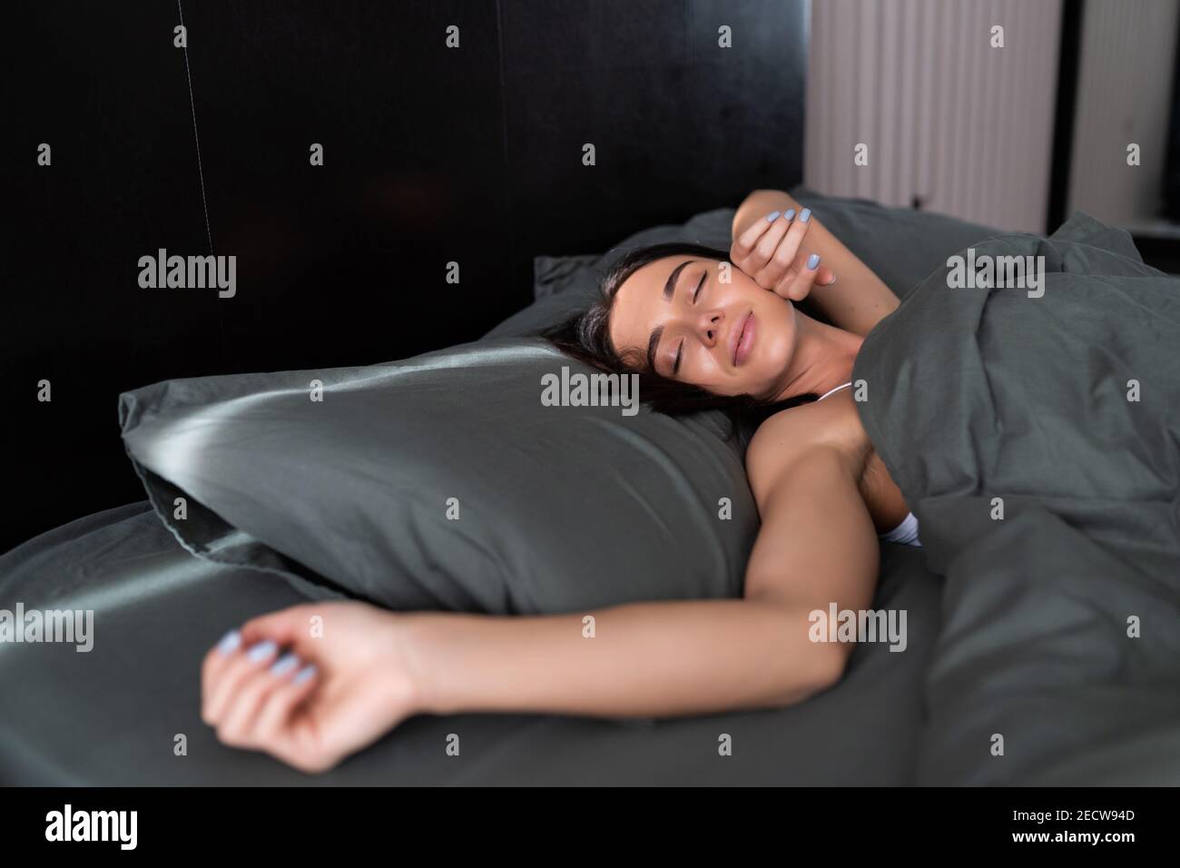 Image of young smiling pretty lady lies in bed indoors. Eyes closed Stock Photo - Alamy