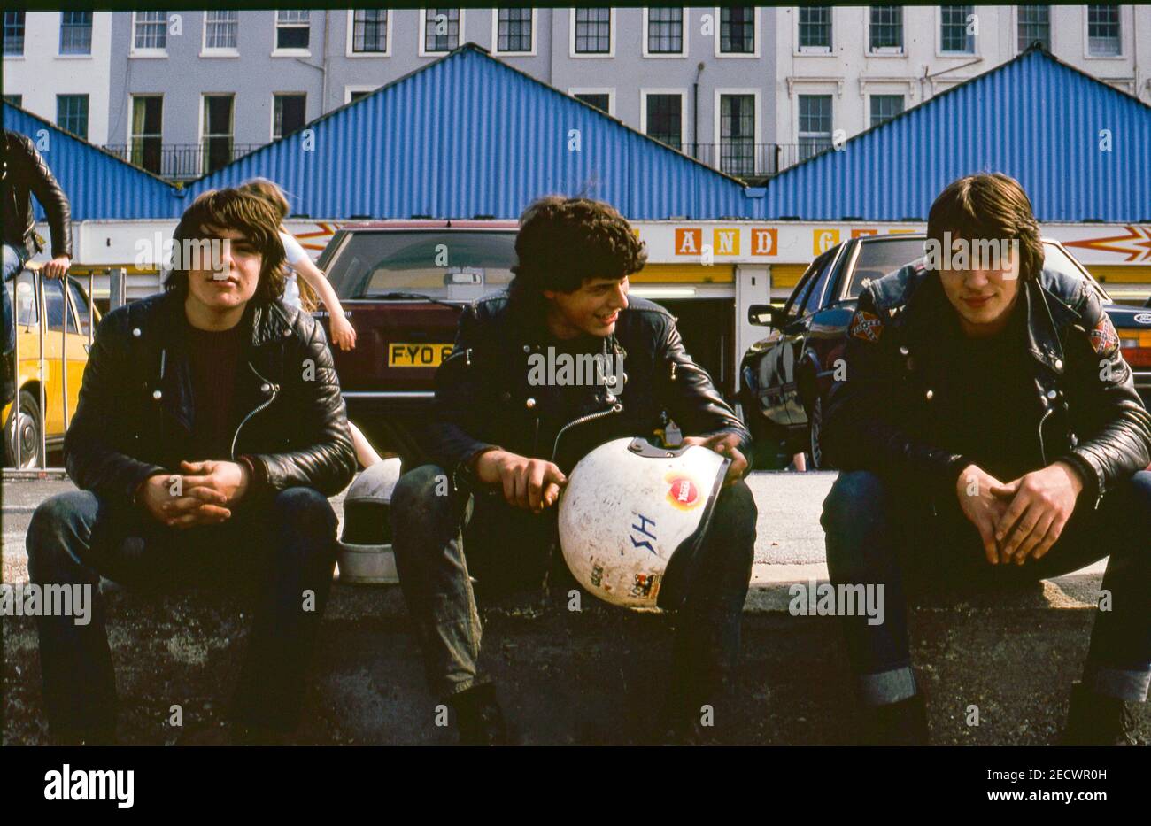 Teenagers Sitting on Railings Outside Arcade Stock Photo - Alamy