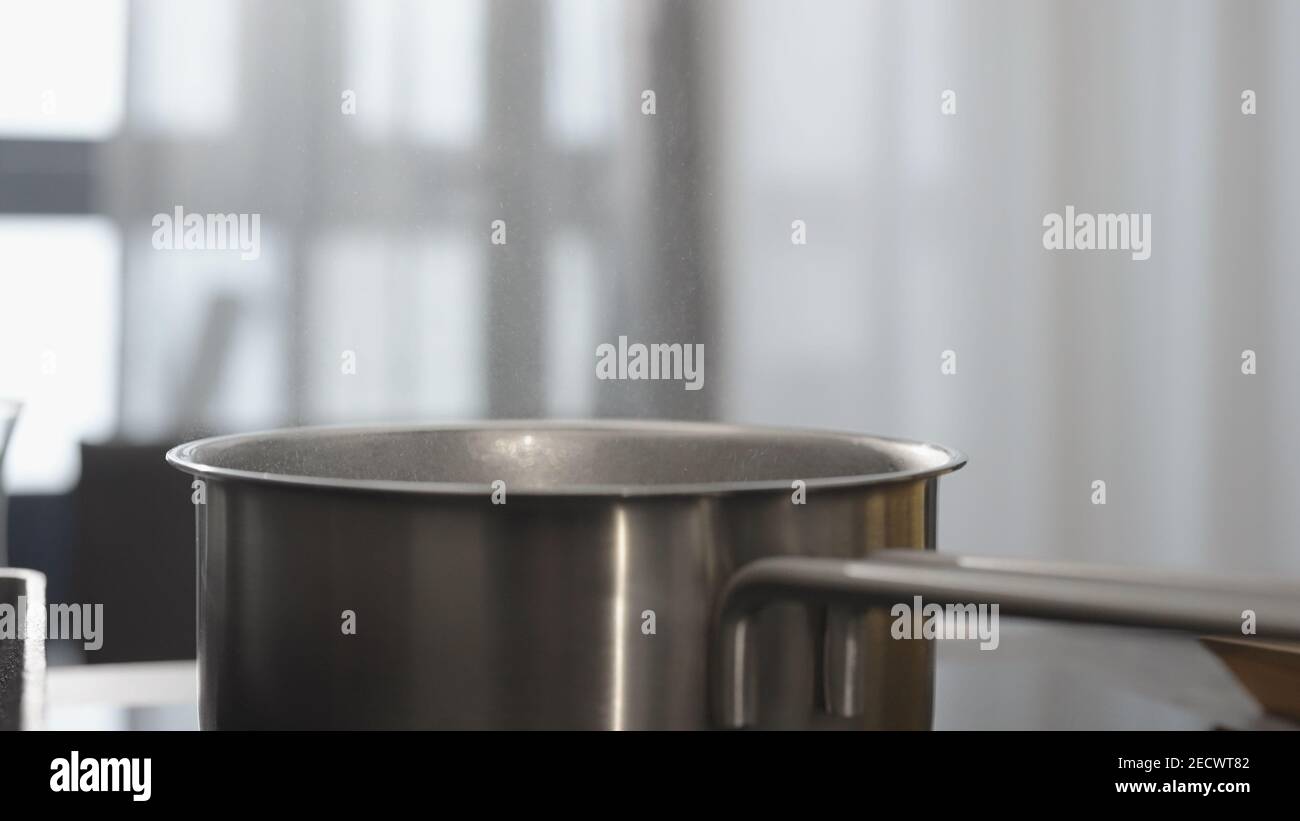 water boil on saucepan on kitchen stove with back light, wide photo ...