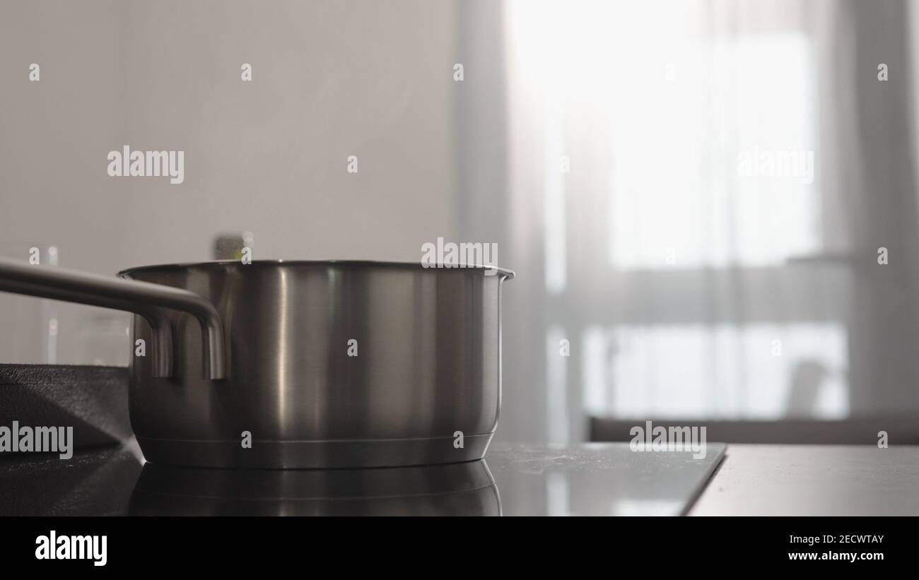 water boil on saucepan on kitchen stove with back light, wide photo ...