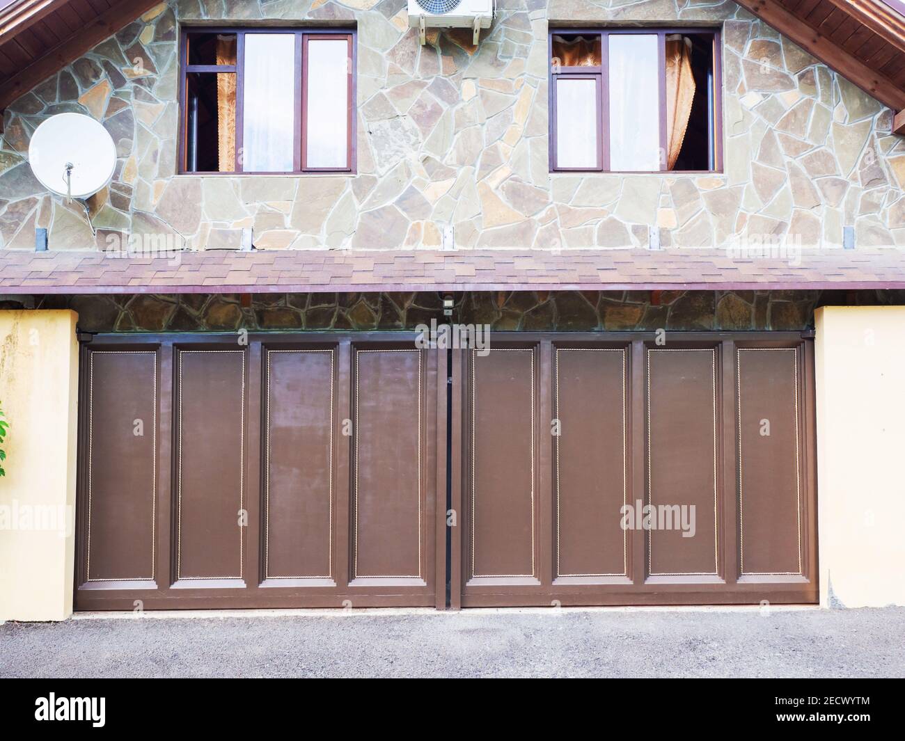 House with two windows, decorative granite cladding and brown iron ...