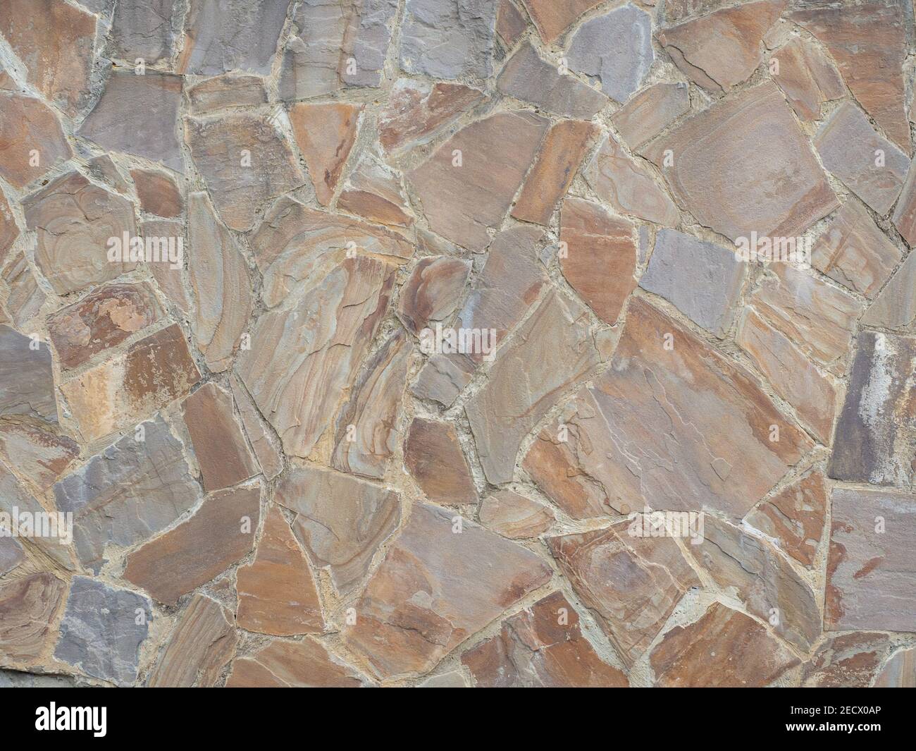 Wall with decorative rough granite masonry of various shapes. Closeup ...