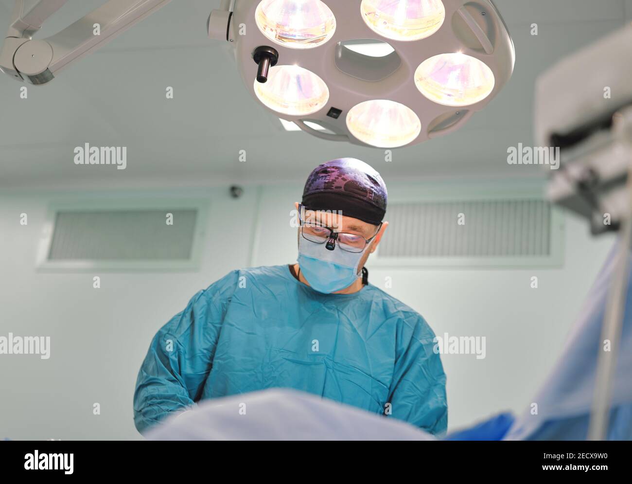 Team surgeons are performing an operation, handsome middle aged doctor ...