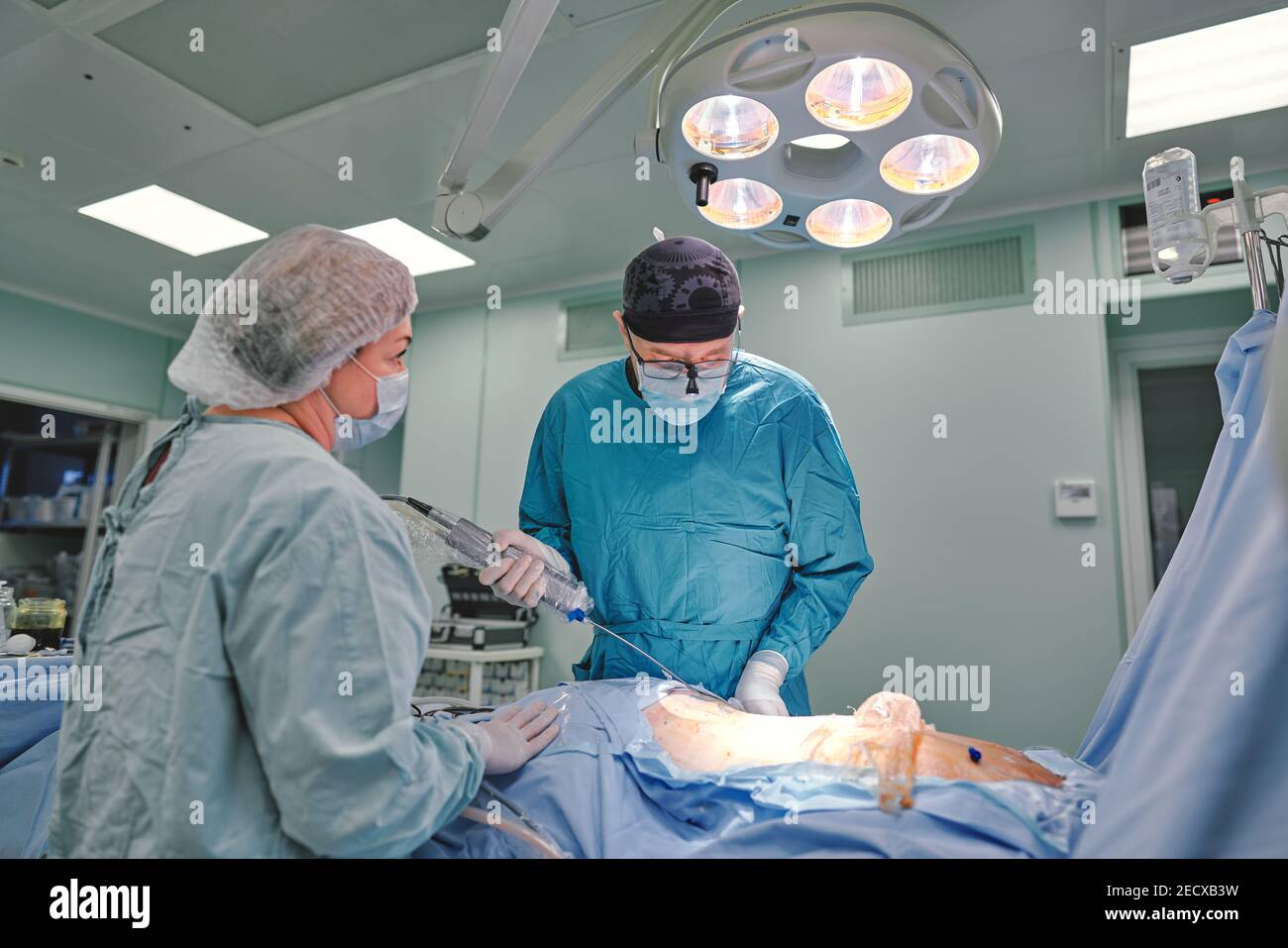 surgeon during liposuction in the operating room Stock Photo - Alamy