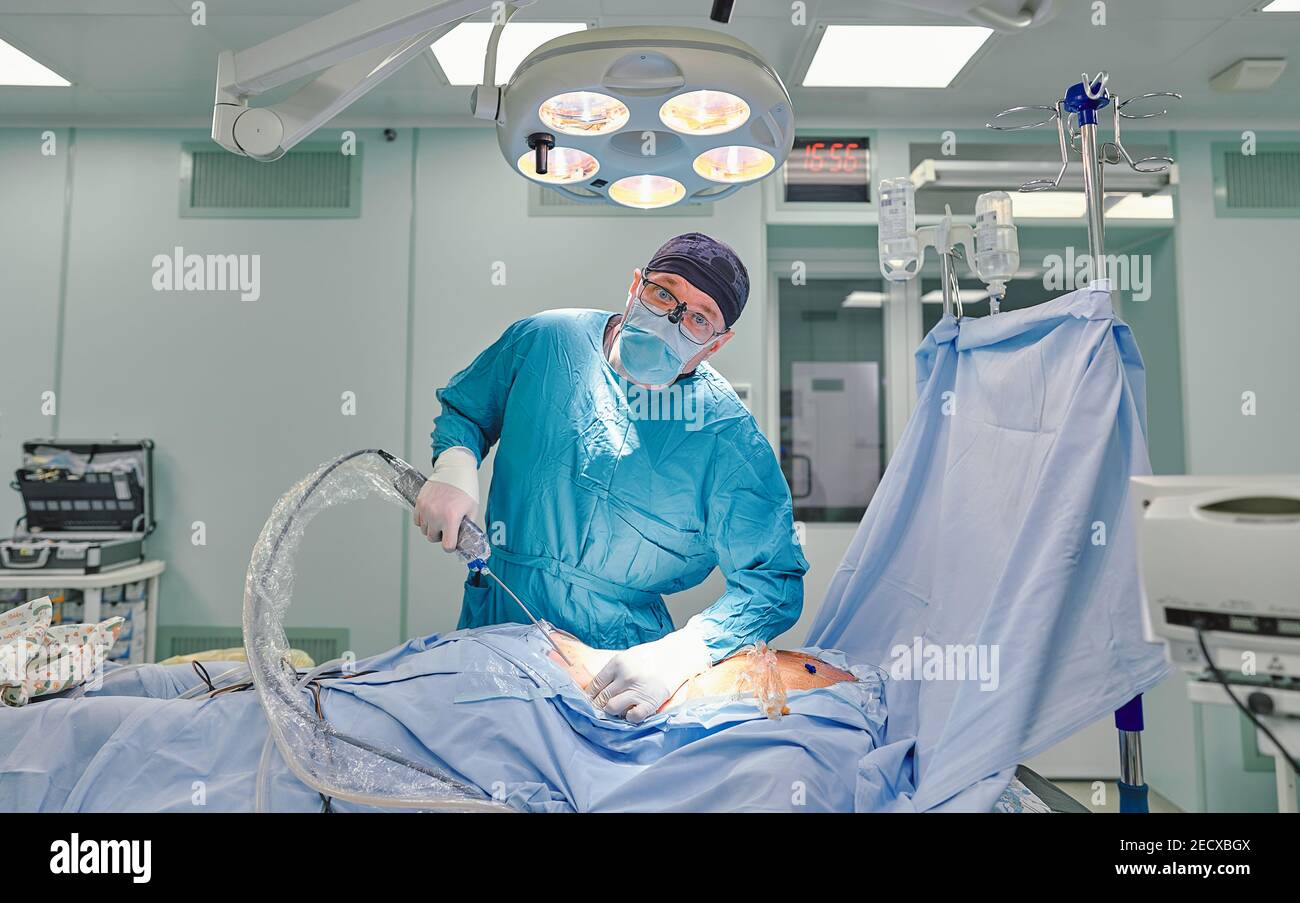 surgeon during liposuction in the operating room Stock Photo - Alamy