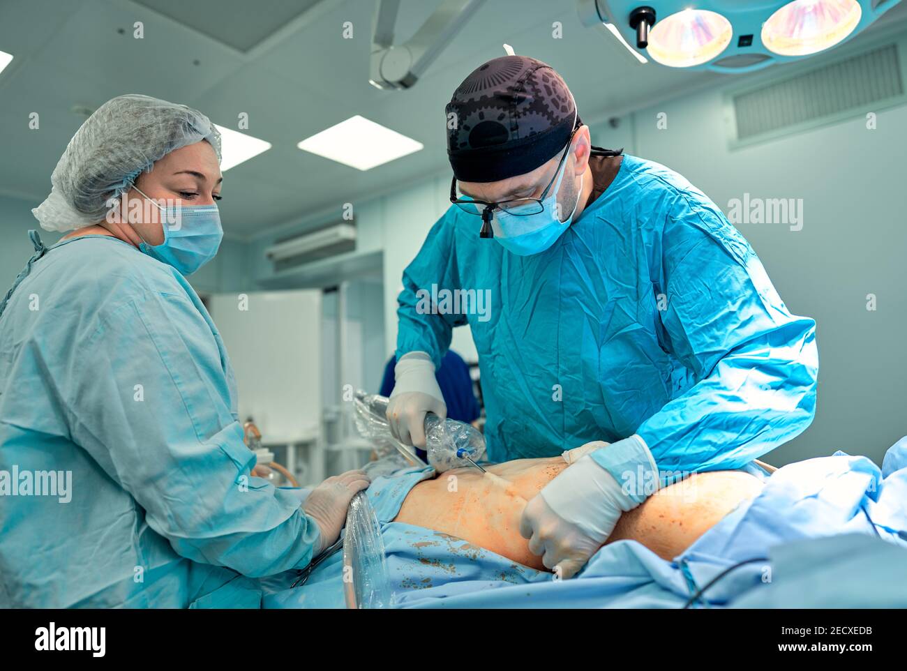 surgeon during liposuction in the operating room Stock Photo - Alamy