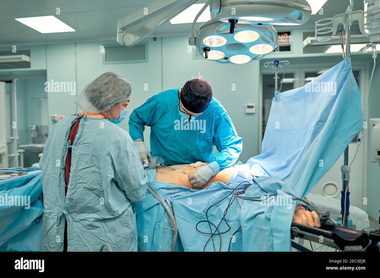 surgeon during liposuction in the operating room Stock Photo - Alamy