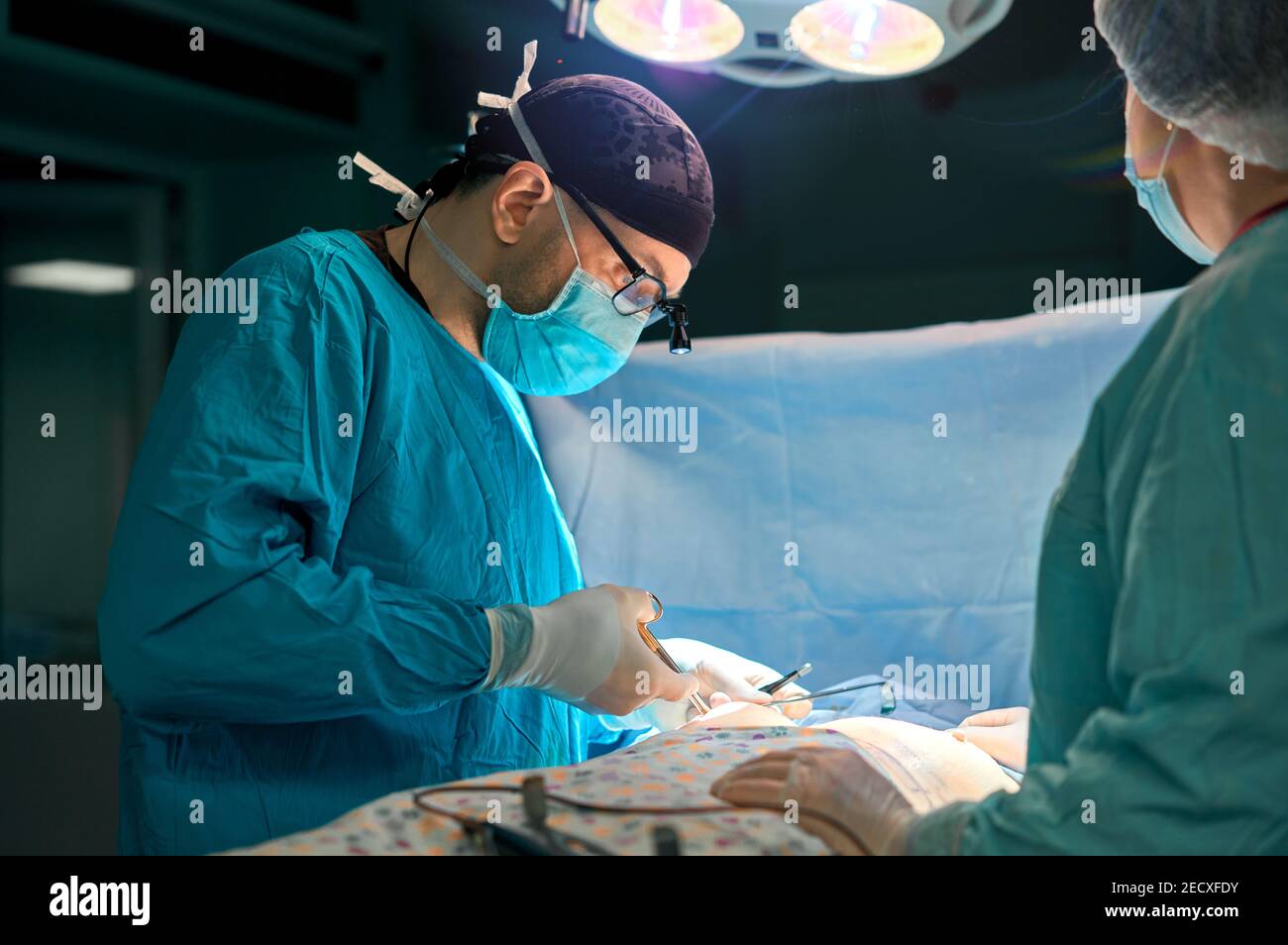 Team surgeons are performing an operation, handsome middle aged doctor ...