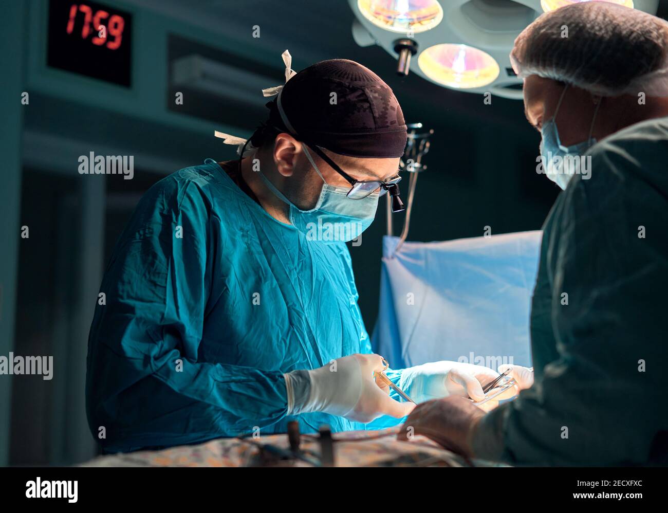 Team surgeons are performing an operation, handsome middle aged doctor ...