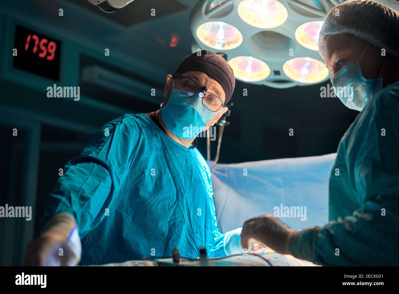 Team surgeons are performing an operation, handsome middle aged doctor ...