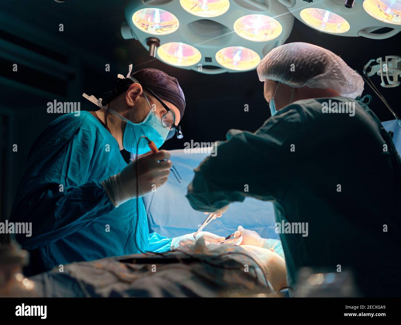 Team surgeons are performing an operation, handsome middle aged doctor ...