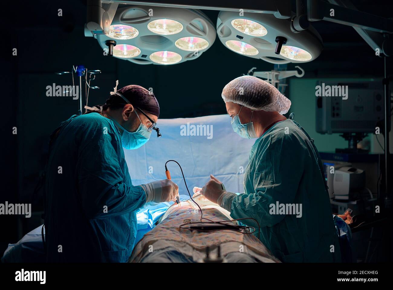 Team surgeons are performing an operation, handsome middle aged doctor ...