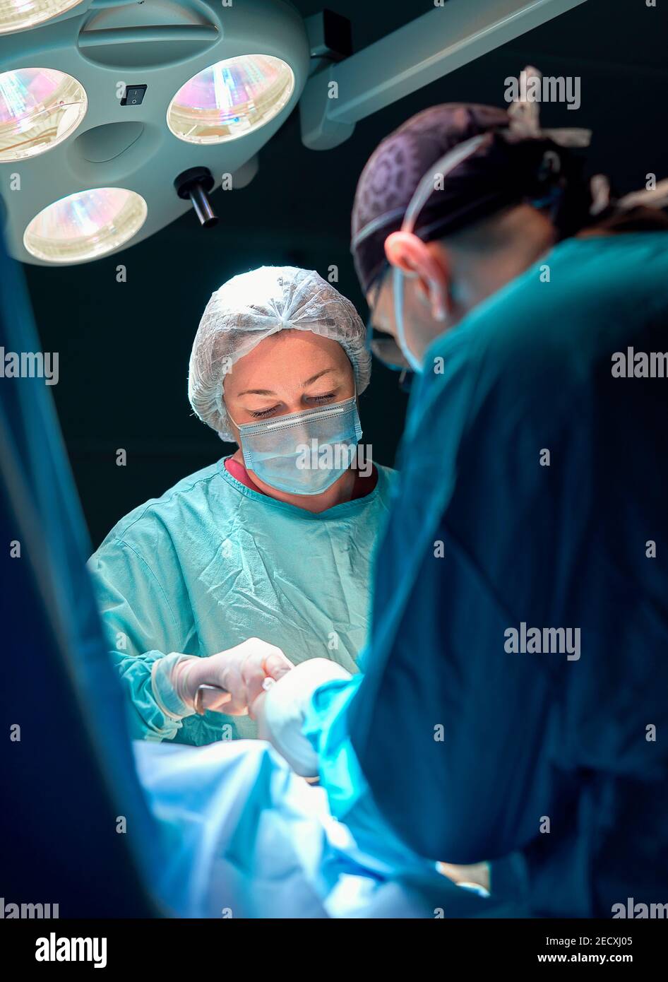 Team surgeons are performing an operation, handsome middle aged doctor ...