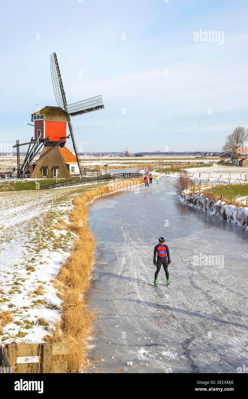 Iconic Dutch winter scene, ice skating in a polder landscape with the ...