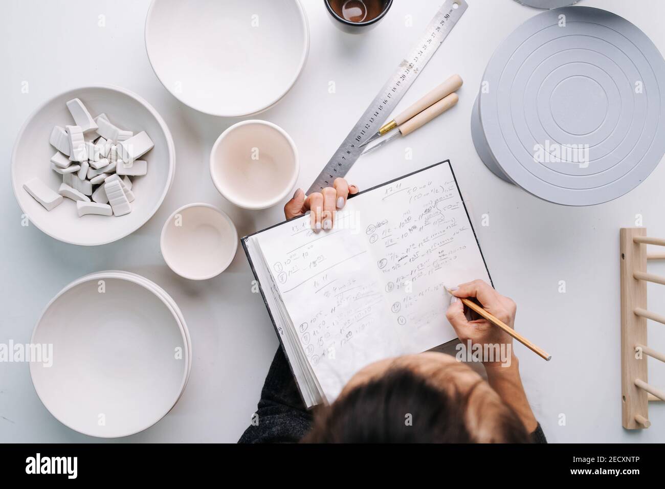 Top view of a woman writing notes next to a table with new blank ...
