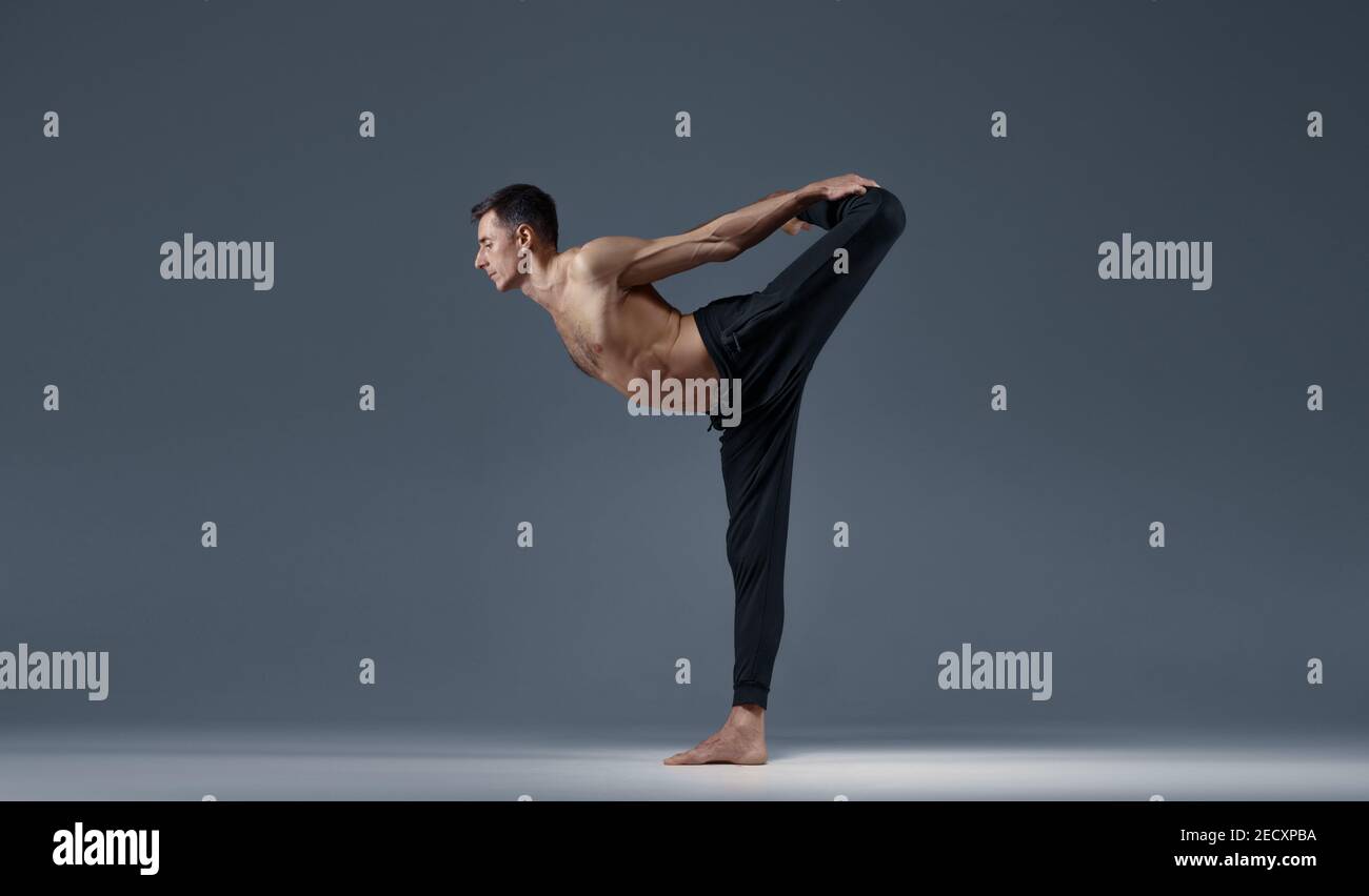 Male yoga keeps balanc in a difficult pose Stock Photo - Alamy
