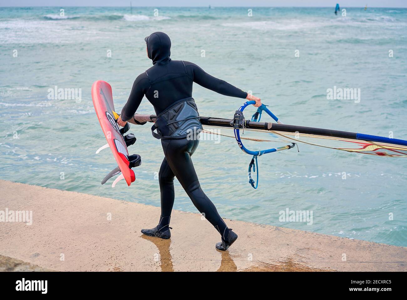 winter Windsurfing, the man in the wetsuit windsurfs in the winter, in ...