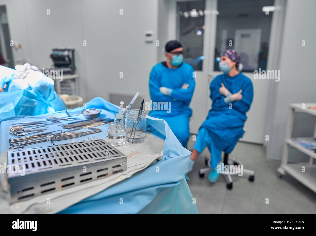 Professional surgeon sitting in operating room with empty table and no ...
