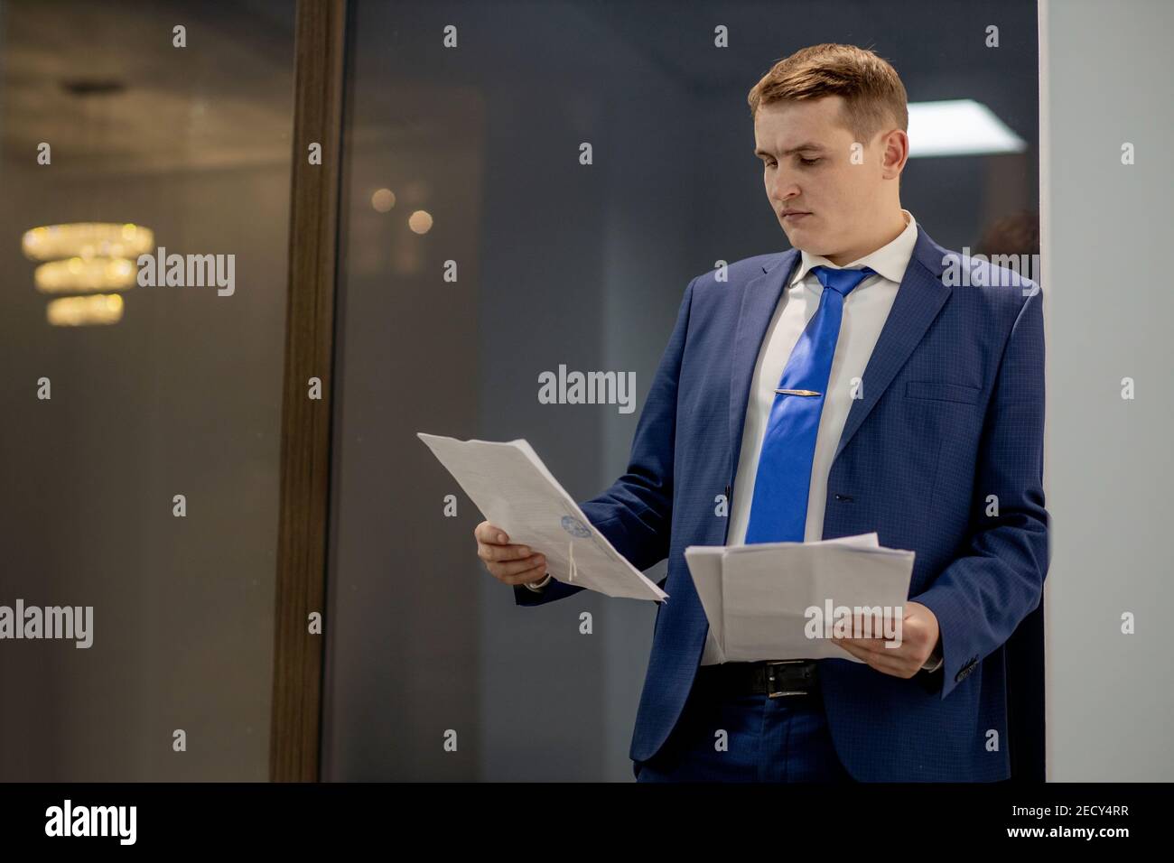 Young businessman working with documents looking through papers in ...