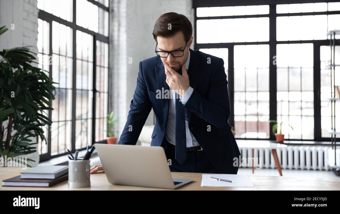 Pensive businessman look at laptop screen solving problem Stock Photo ...