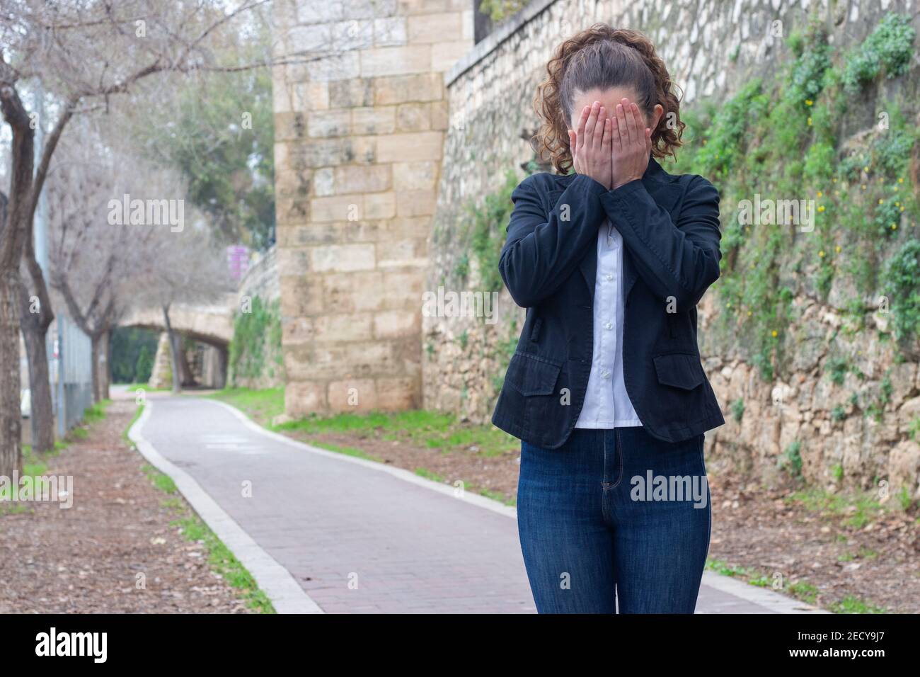 A sad disappointed girl closing her face with her hands Stock Photo - Alamy