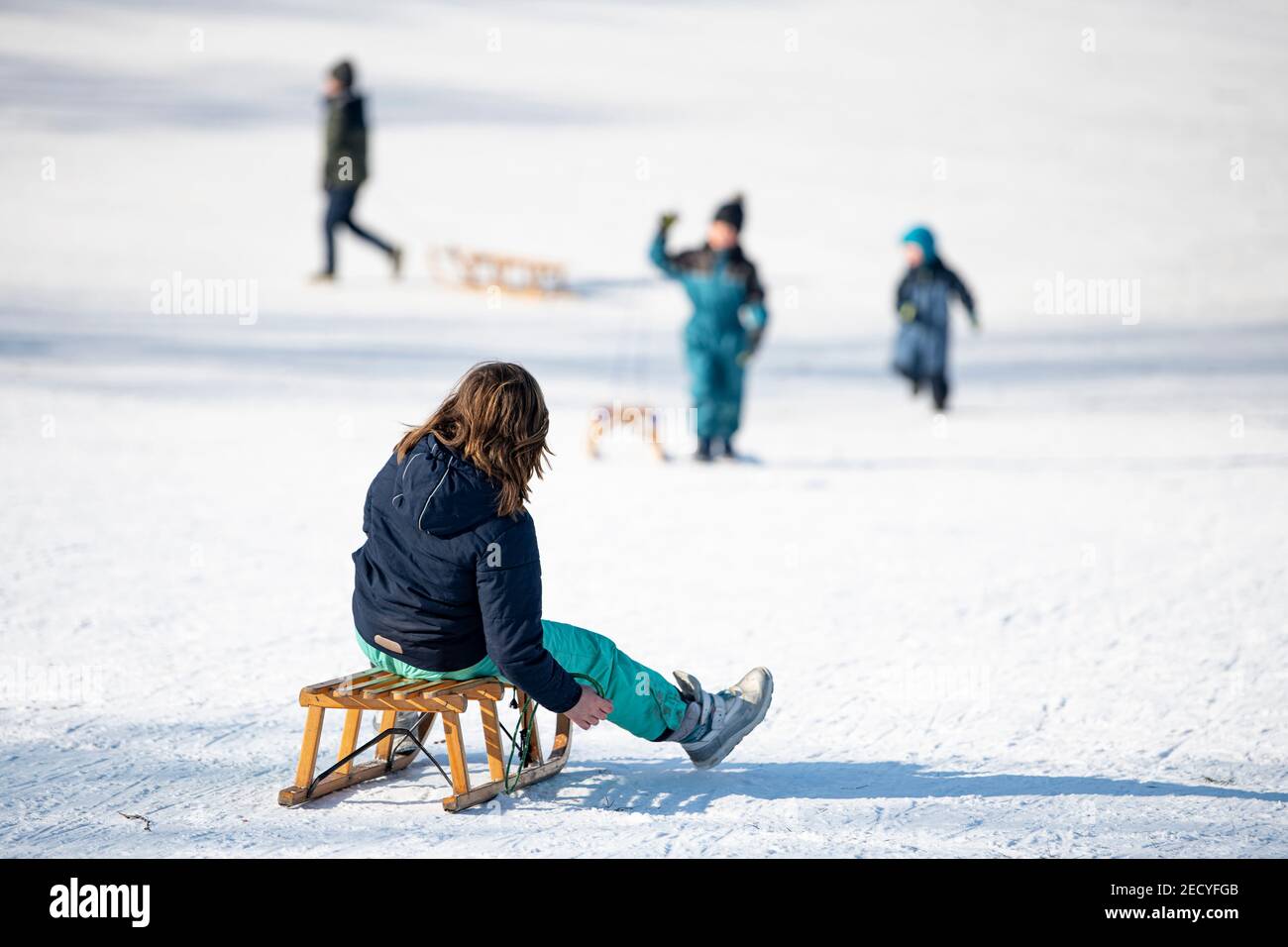 14 February 2021, Berlin: A child sleds down a hill in Görlitzer Park ...