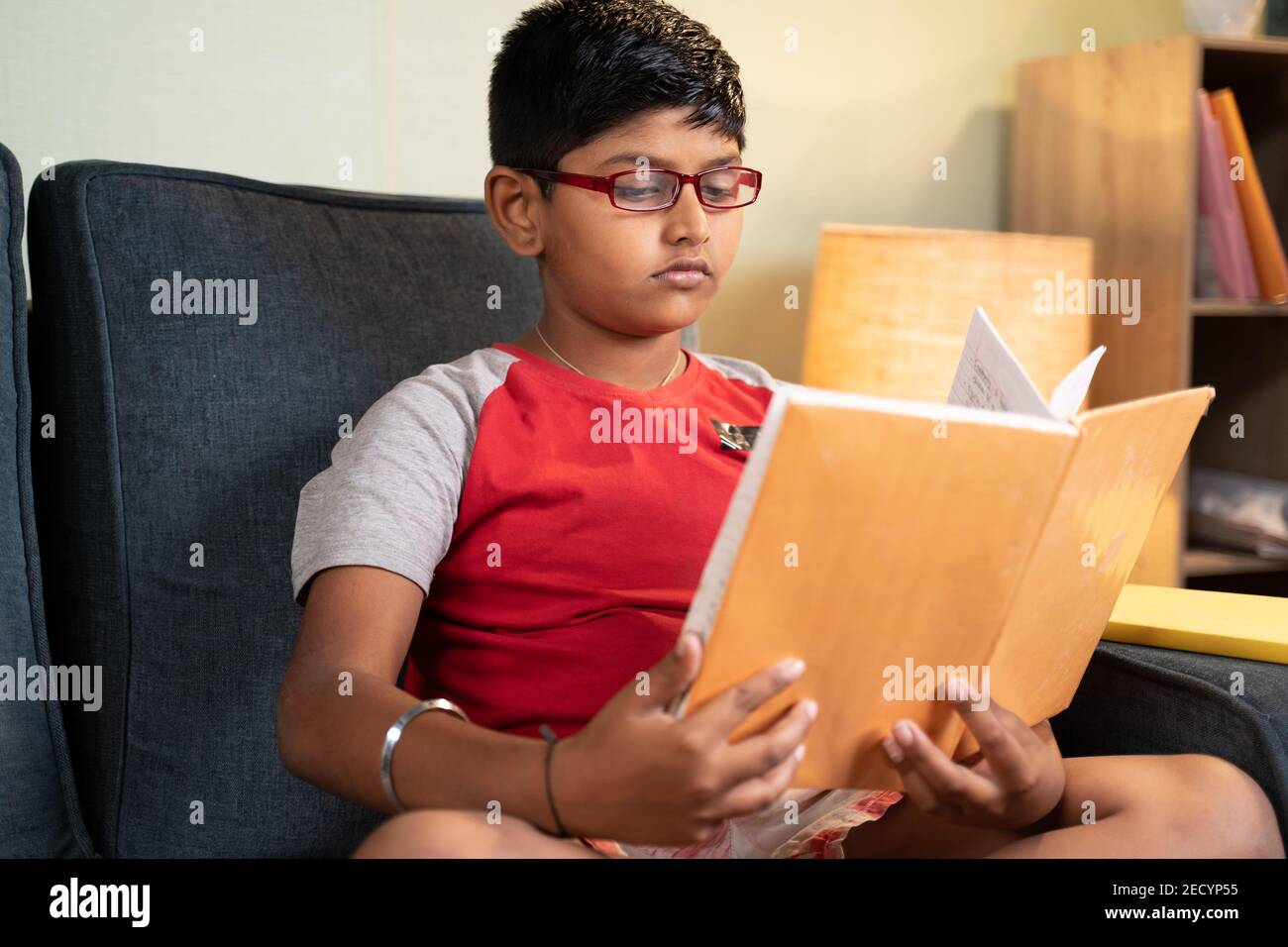 Young kid busy reading from book for exam at home - concept of ...