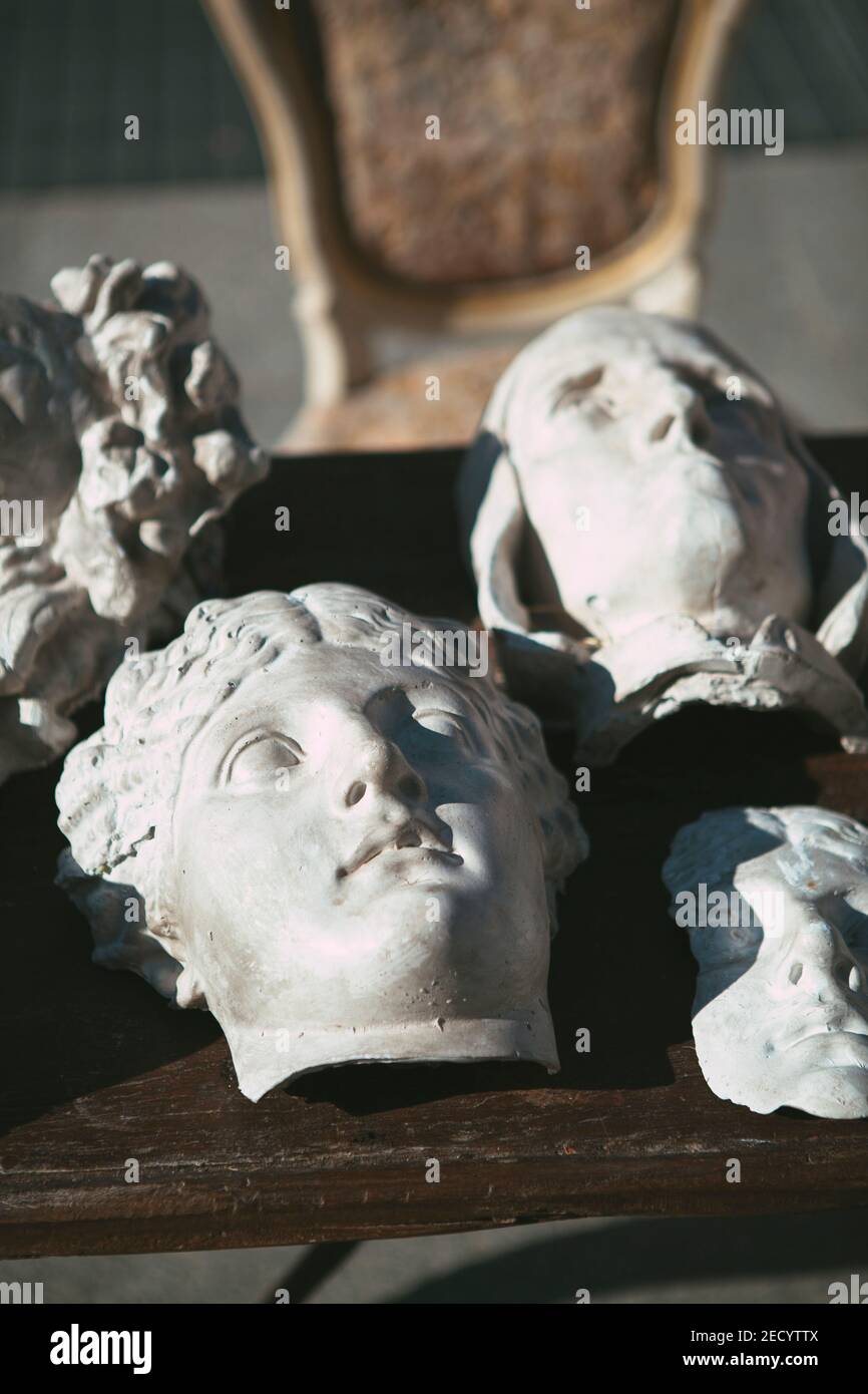 Close up. White plaster heads and faces of statues, interior details ...