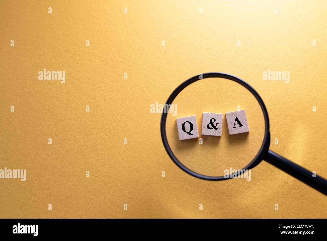 Magnifying glass focus on Q&A wooden alphabet letter. Concept of ...