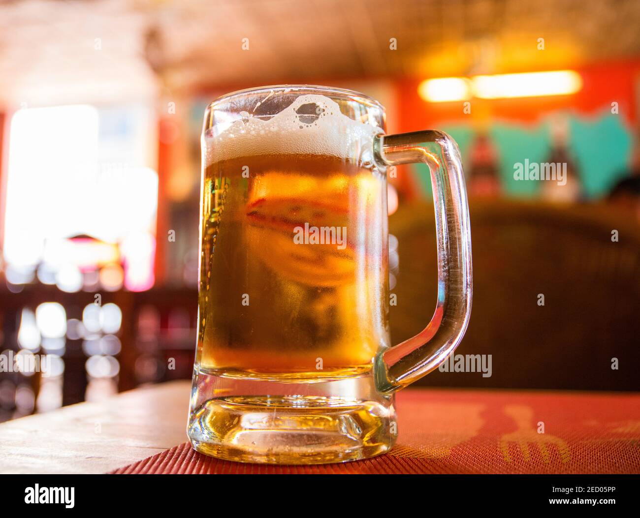 Drinking beer in daytime. Transparent glass mug with beer on wooden ...