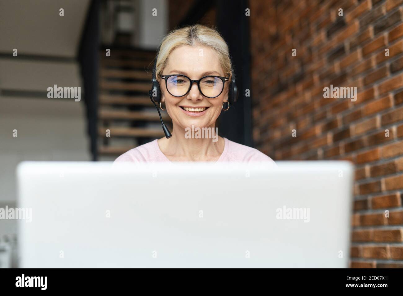 Secretary sitting at the computer with headset and looking at the ...