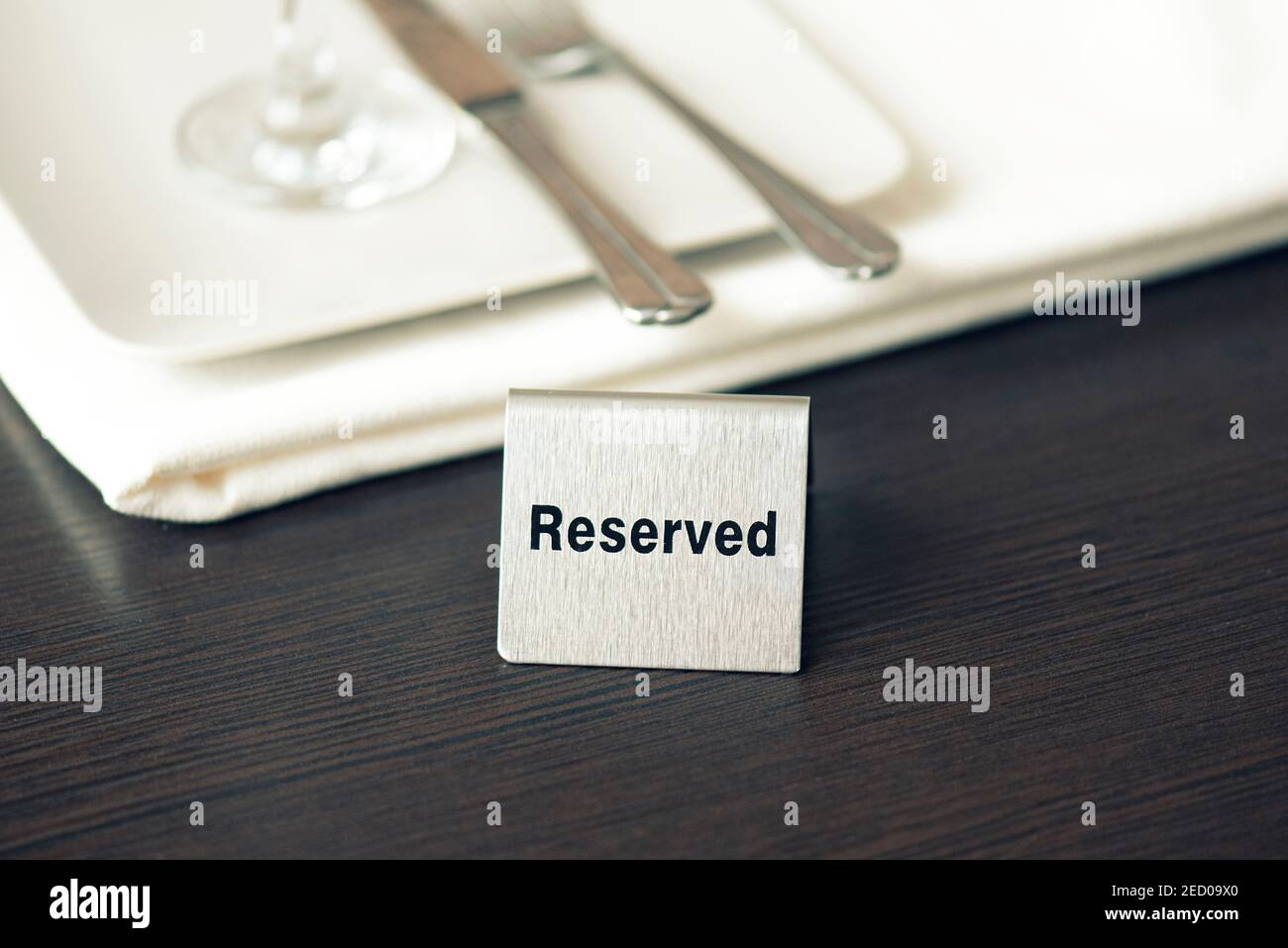 Reserved sign, iron plate on the table at cafe or restaurant, toned ...