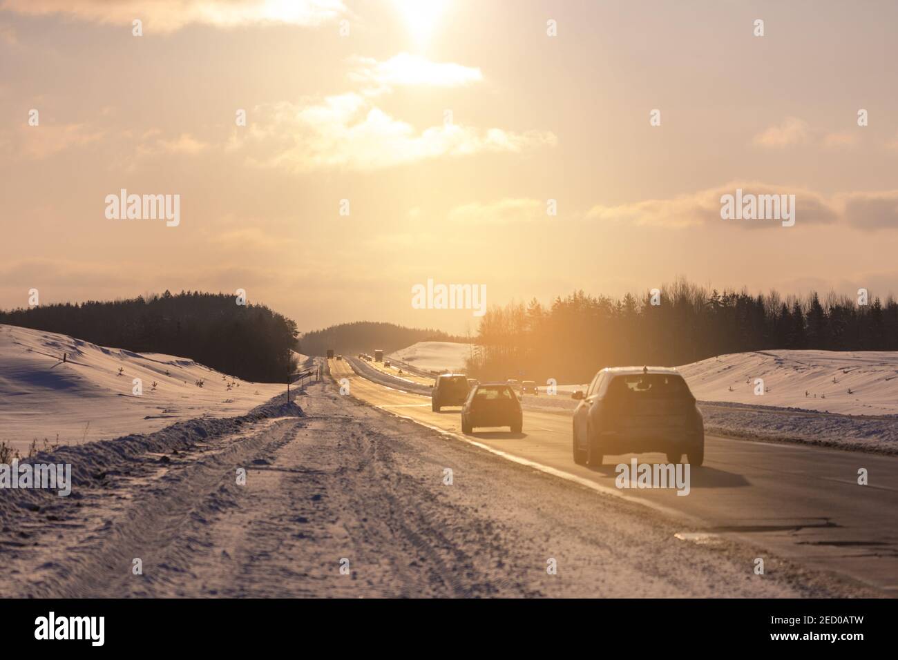Winter road with snow, highway with cars at sunset Stock Photo - Alamy