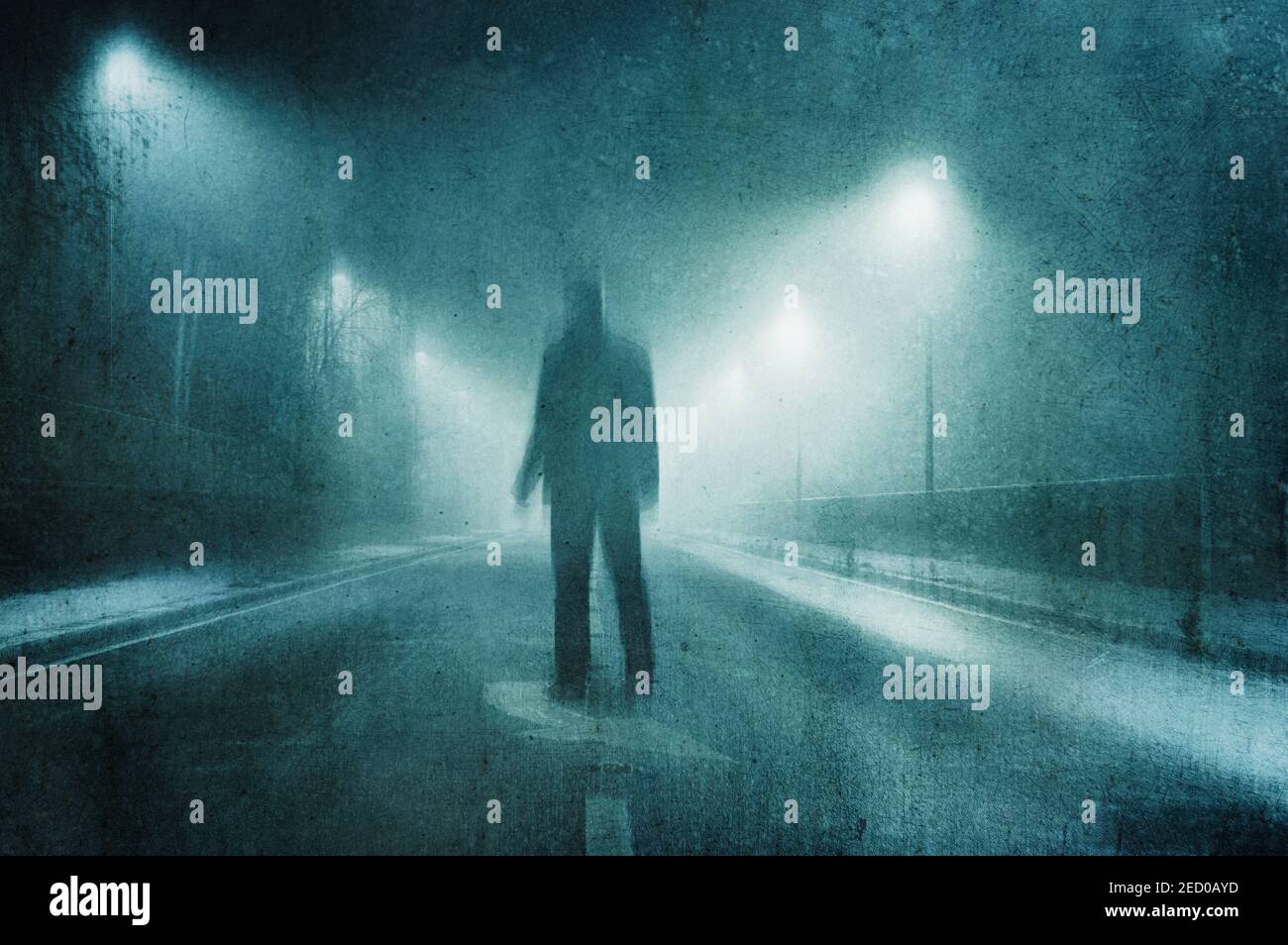 A moody figure, back to camera. Standing in a street on a foggy winters ...