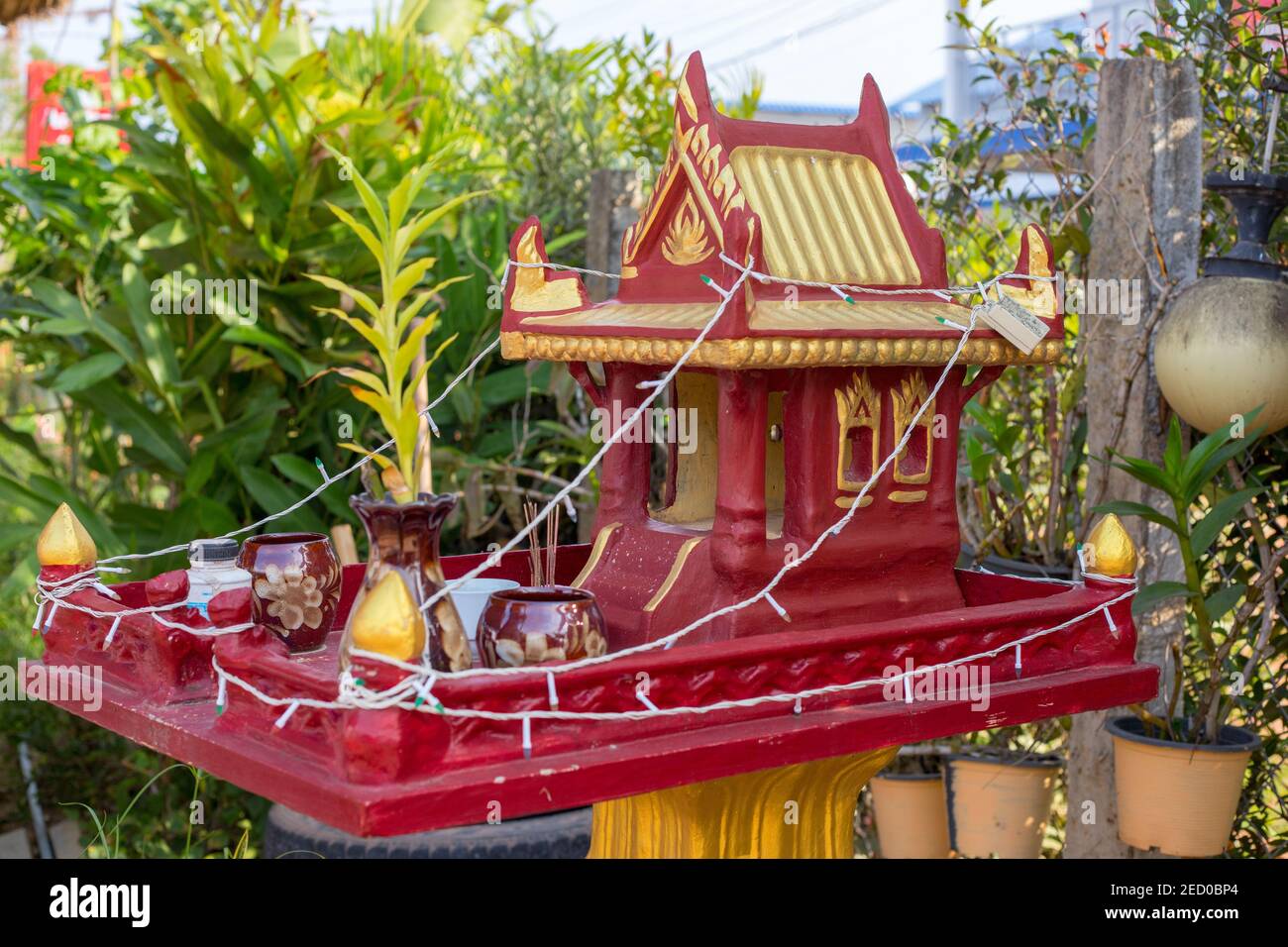 Red and yellow Buddhist sanctuary in tropical garden. Small buddhist ...