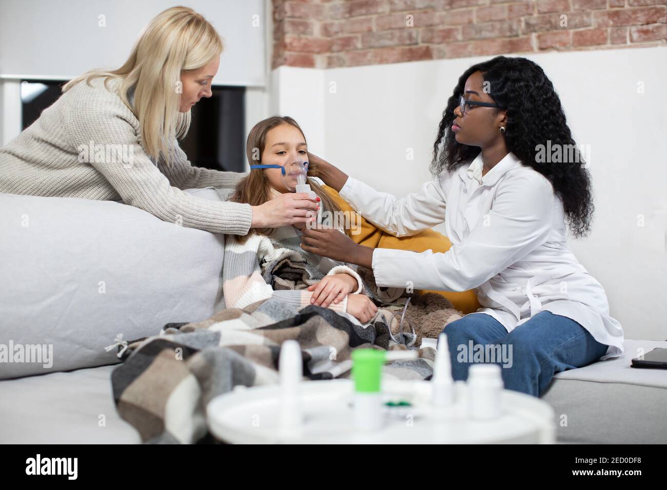 Young attractive high-skilled African lady doctor helping caring mother ...