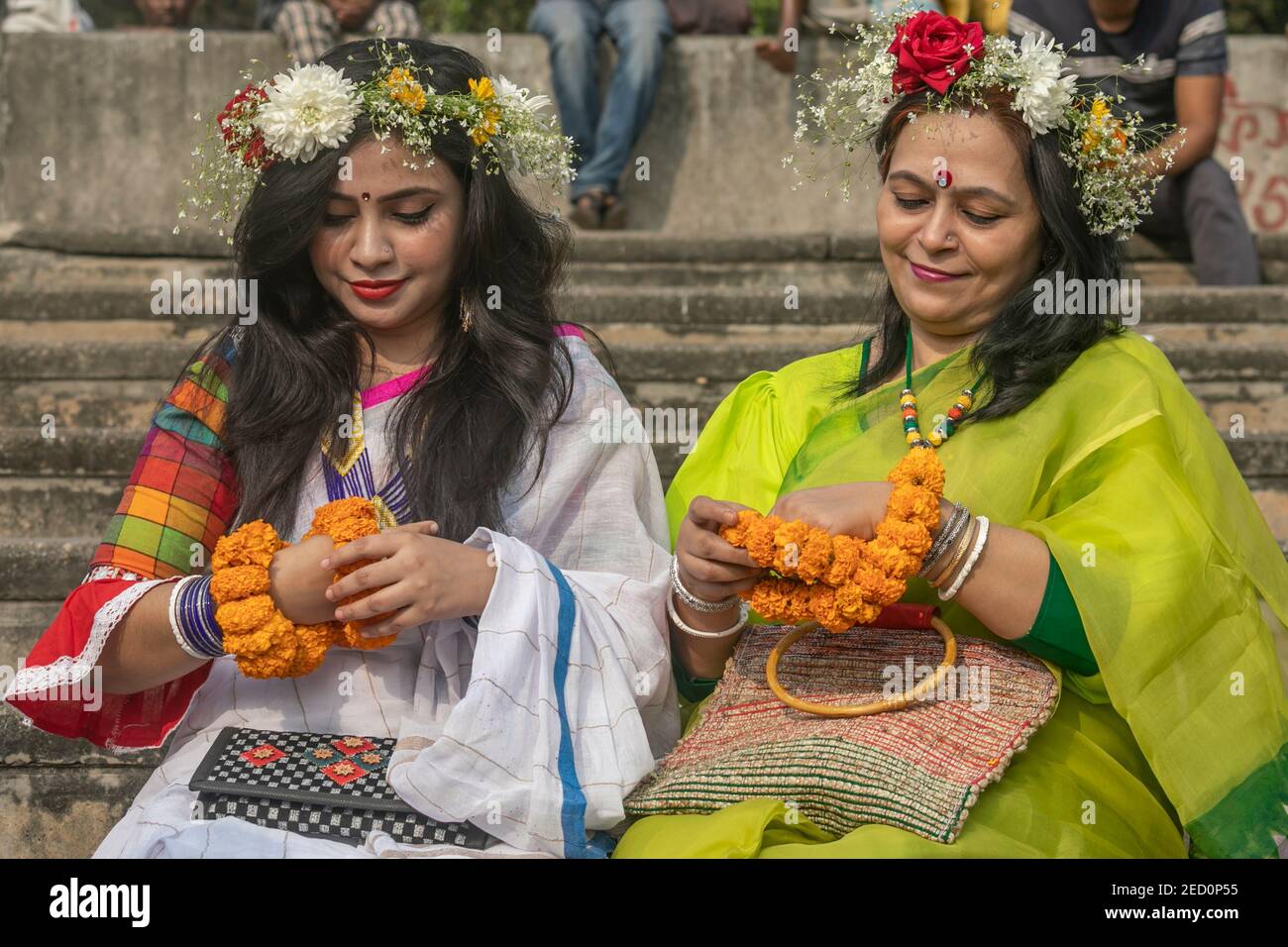 Women wearing traditional saris and flower crowns are seen during the ...