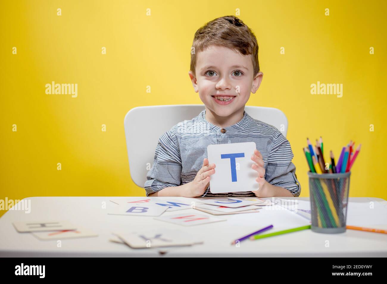 Happy smiling little preschool boy shows letters at home making ...