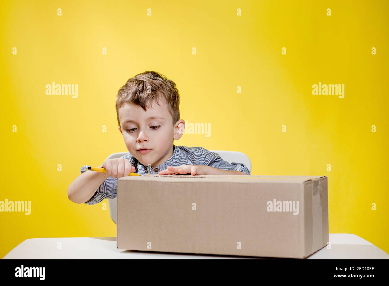 Surprised boy looking opening a box and gasping in surprise seeing the ...