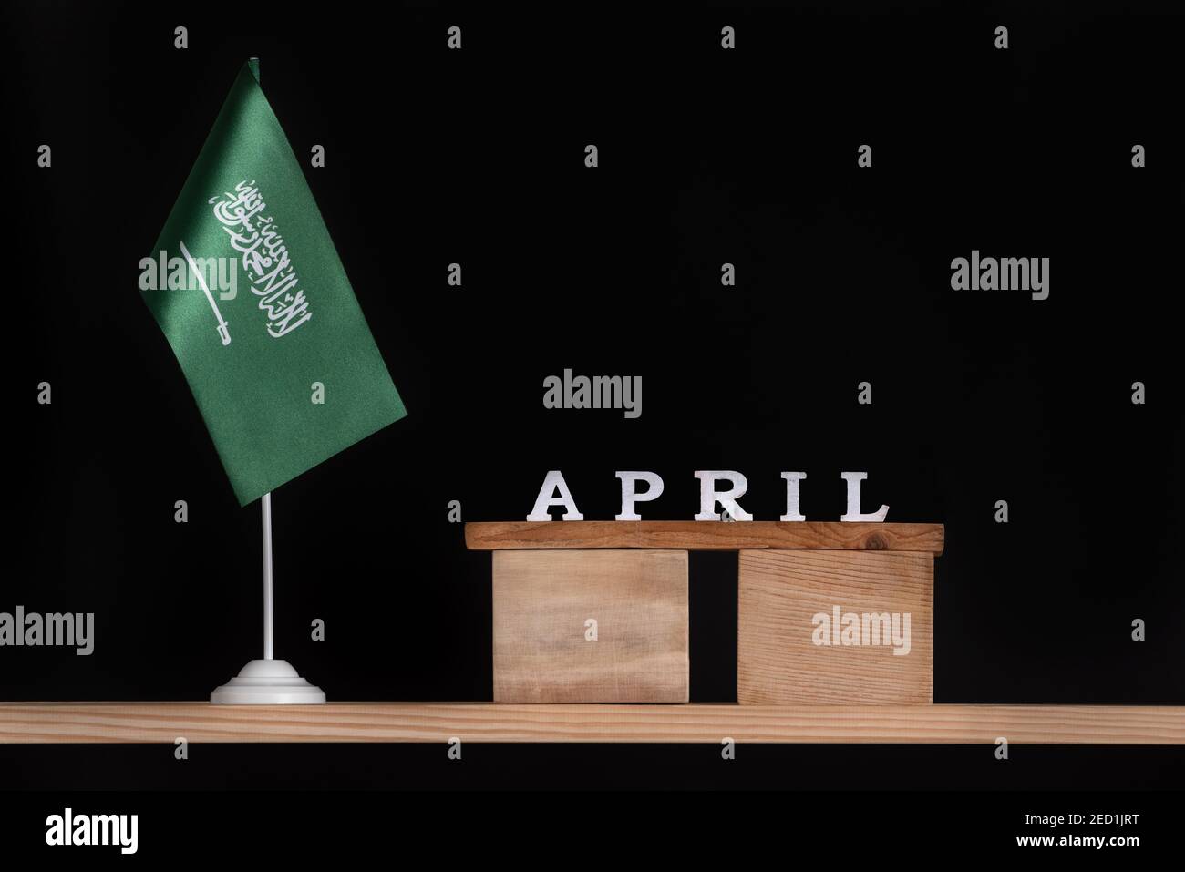 Wooden calendar of April with Saudi Arabia flag on black background ...