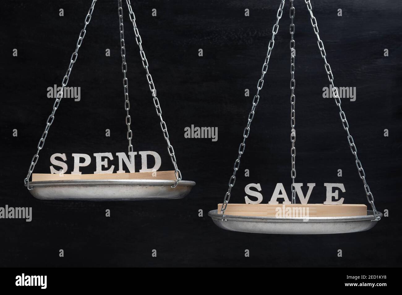 Words SPEND and SAVE in balance. Concept of equilibrium. Scales on ...