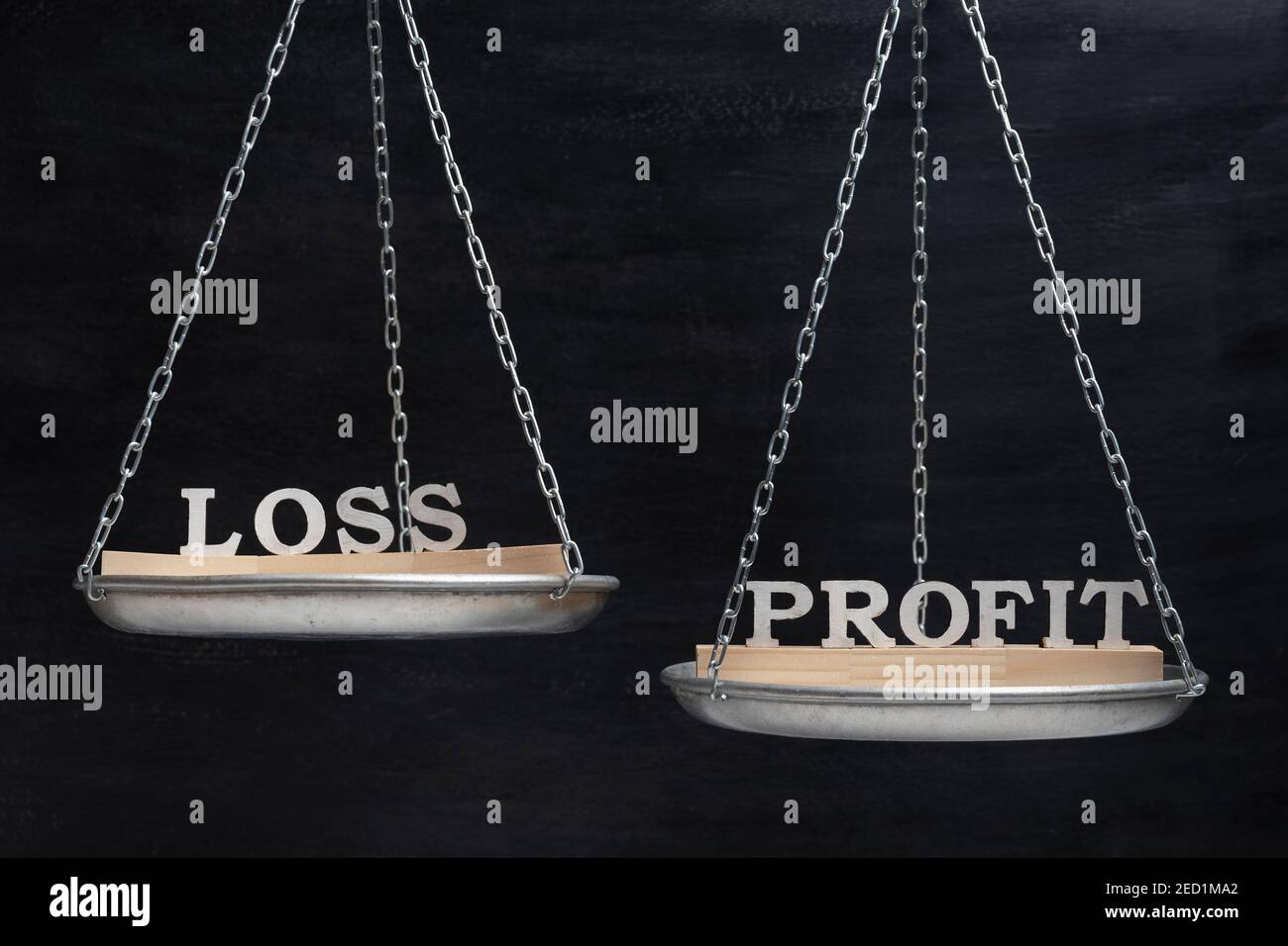 Balance LOSS and PROFIT. Scales on black background close up Stock ...