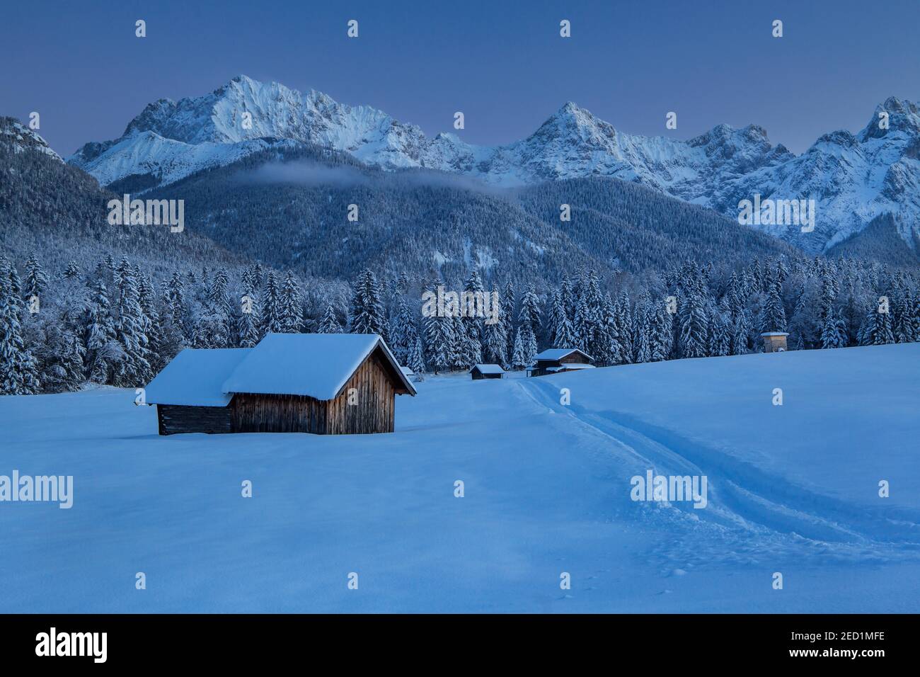 Winterly hummock meadows with hay barn and Karwendel mountains at dusk ...