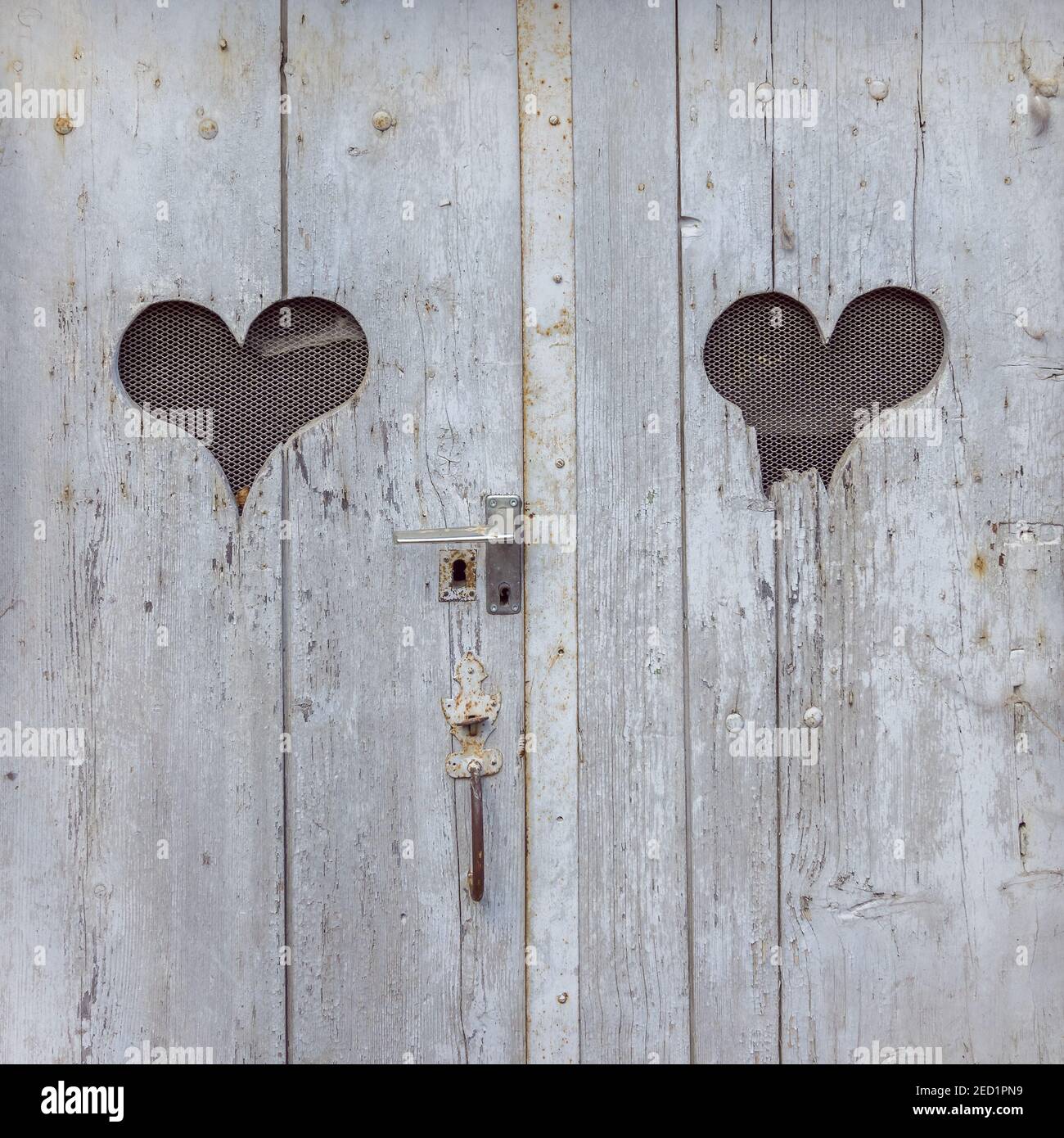 Two heart shapes on antique wooden door representing background for ...