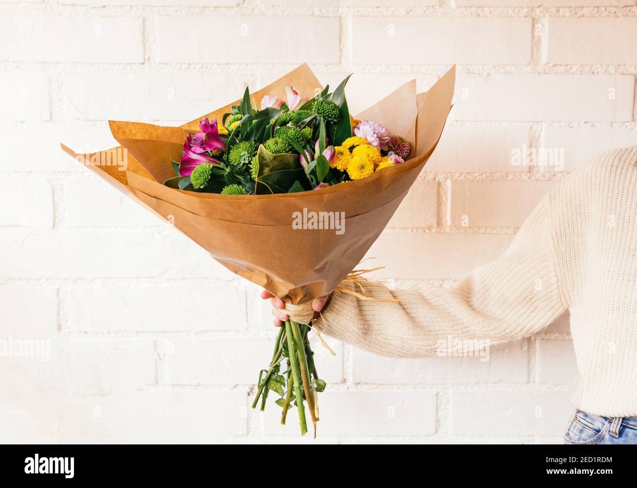 Arm with bunch of fresh colorful flowers on background of the white ...