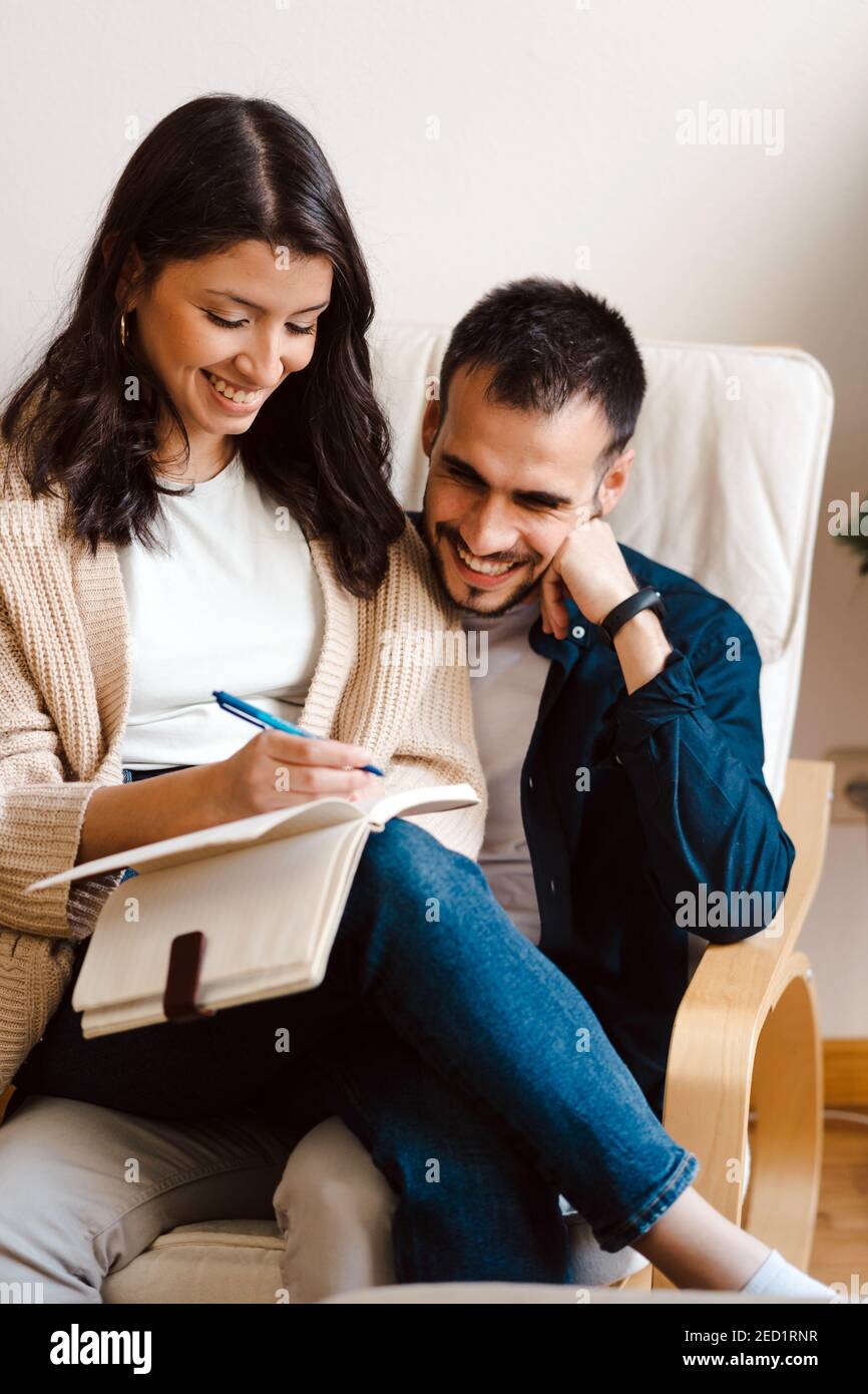 Content couple of musicians sitting together in armchair and taking ...