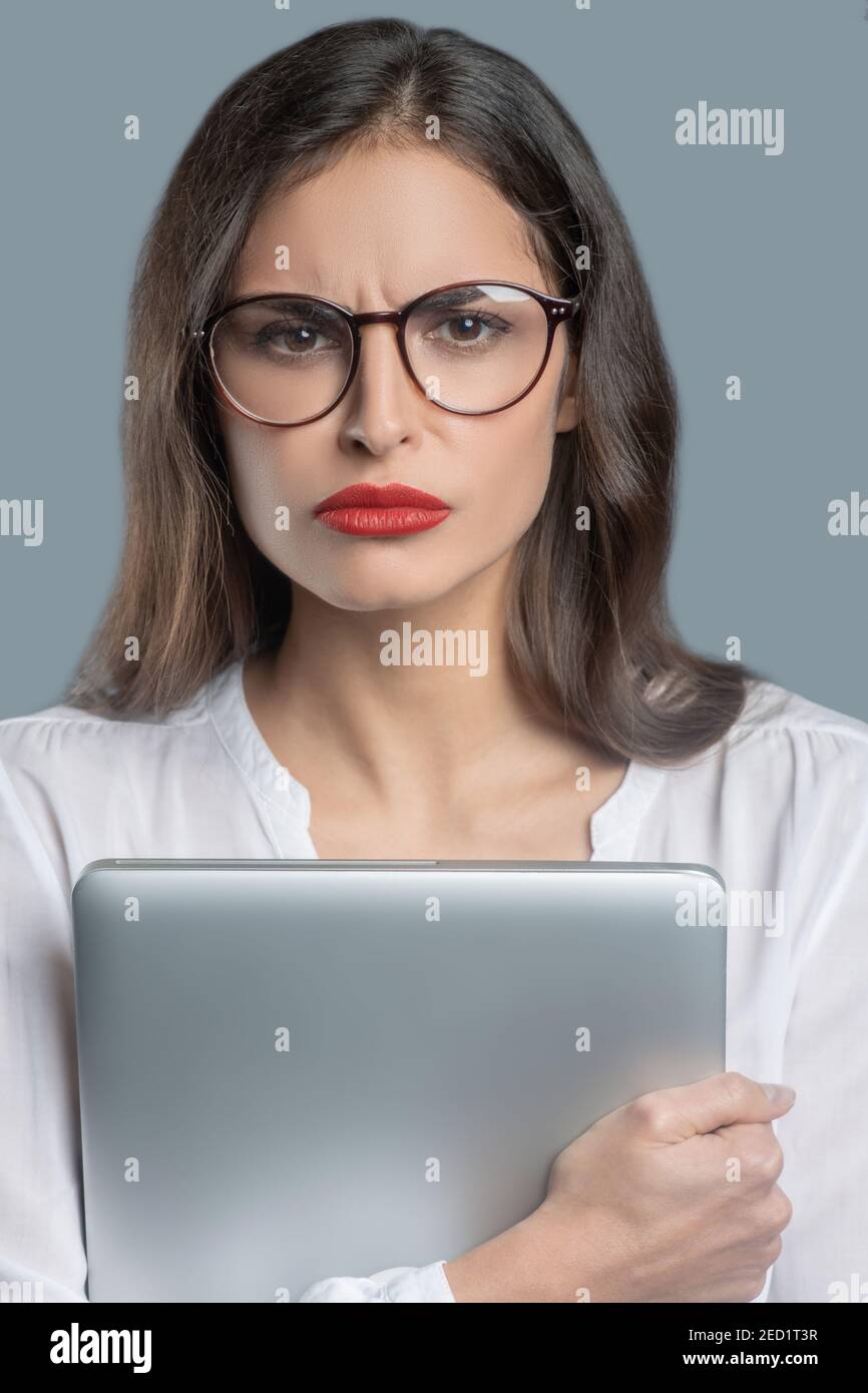 Serious young woman with stern look in glasses Stock Photo - Alamy