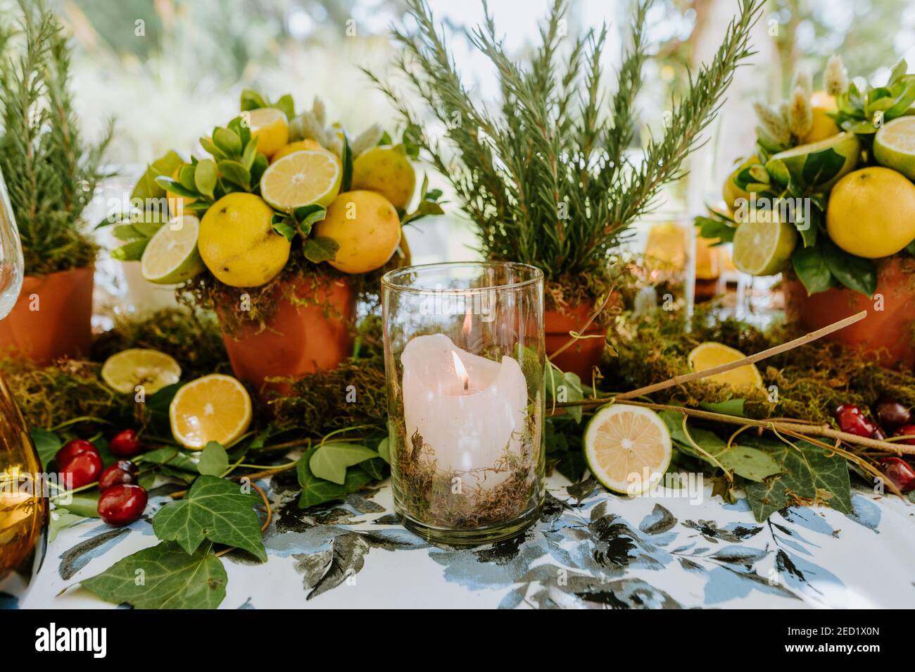 Glass with burning candle placed on served table with creative lemon ...