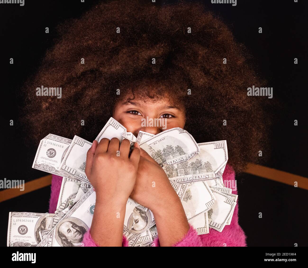 Cheerful wealthy African American teenage girl with heap of dollar ...